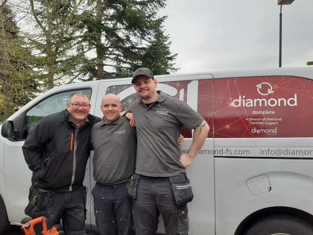 Three Diamond staff stood in front of a Diamond Facilities Support van